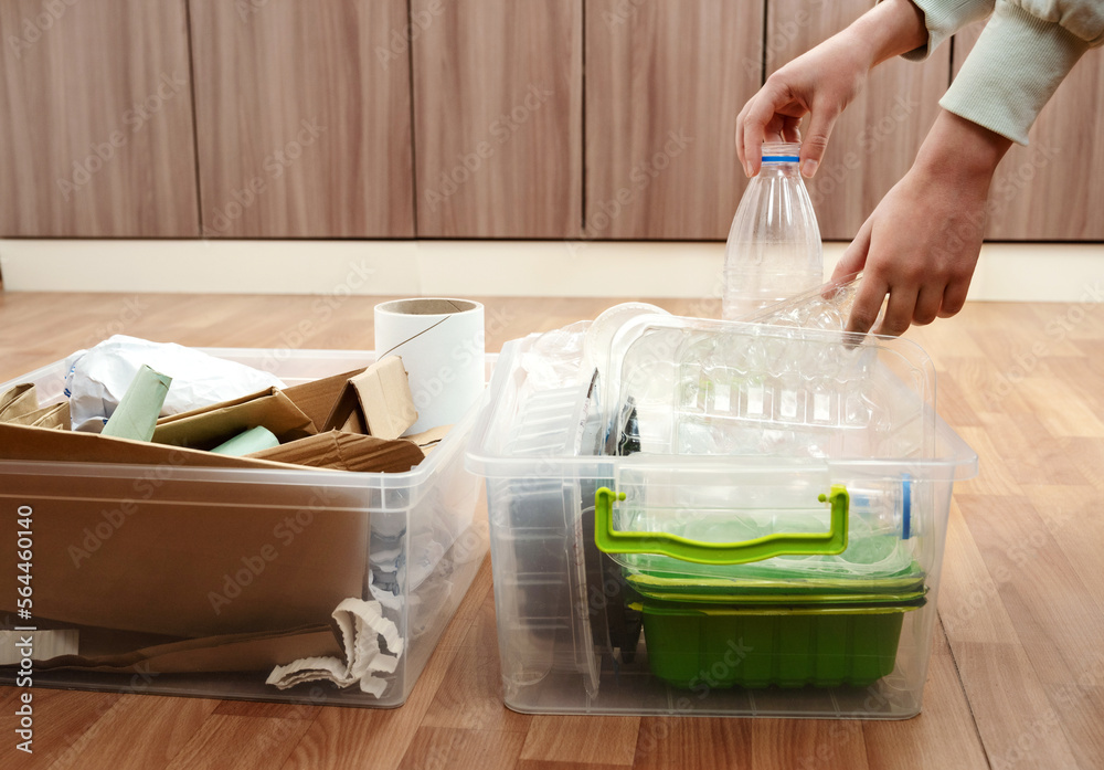Two plastic containers with wastepaper and plastic garbage on floor of ...