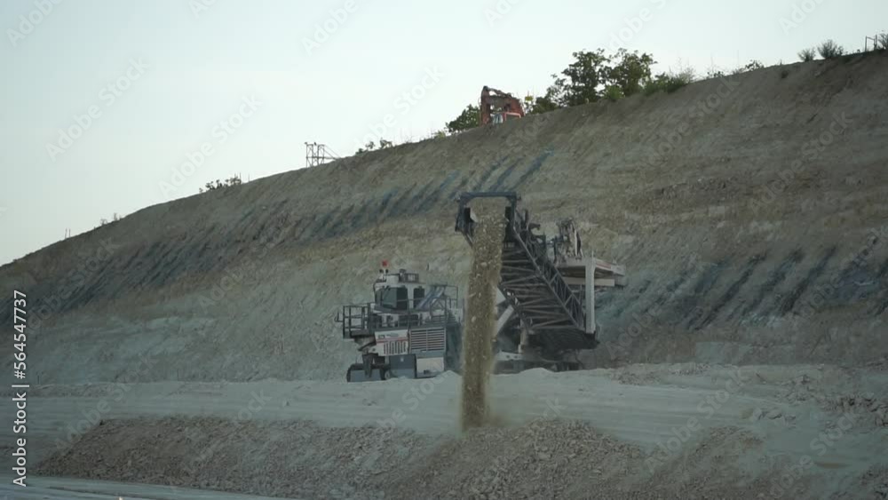 Earth mover cleans up soil for road renewal. Heavy duty mining machine ...