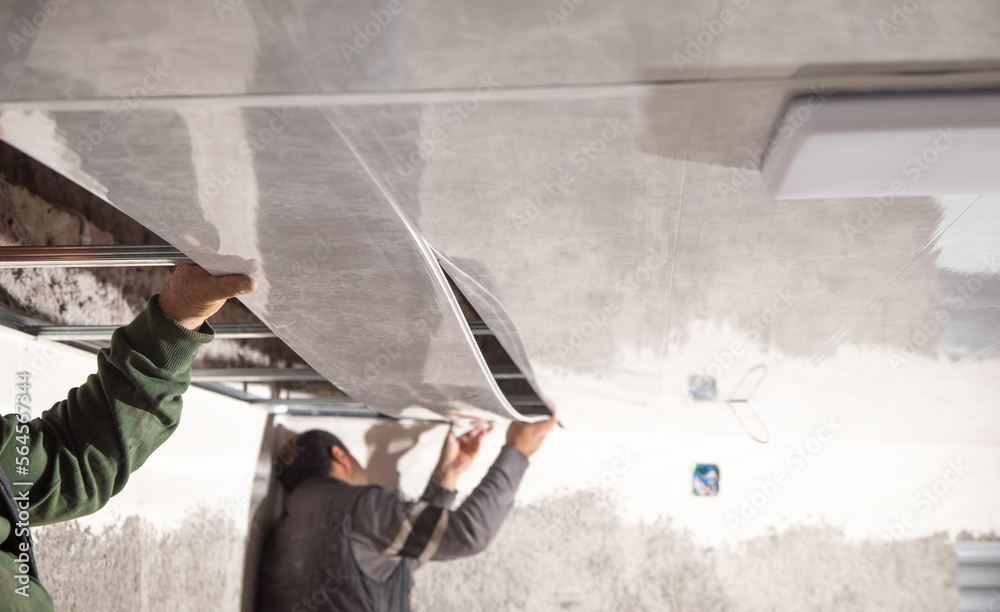Construction worker assemble a suspended ceiling. Stock Photo | Adobe Stock