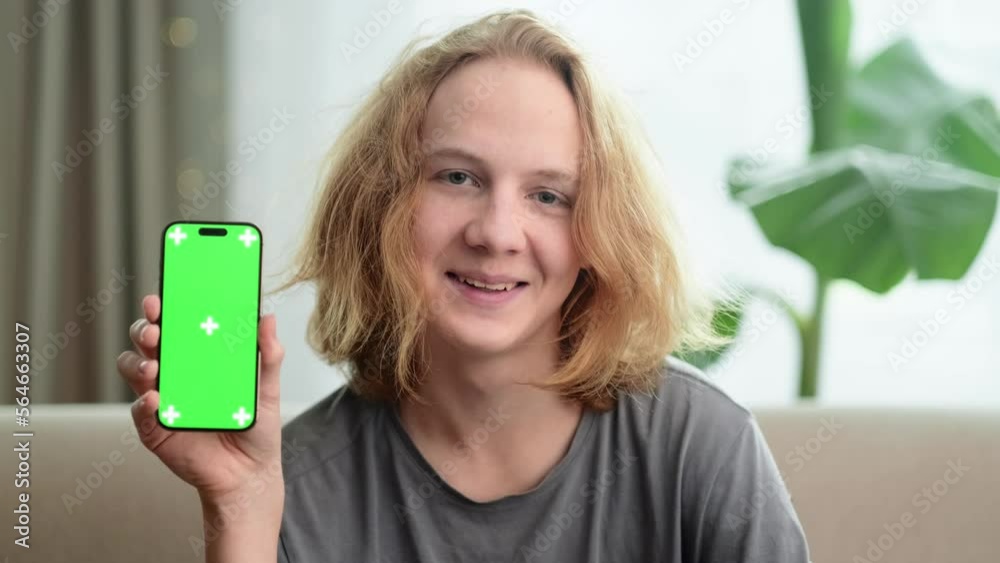 Happy smiling ginger teen boy showing phone with green screen chroma ...