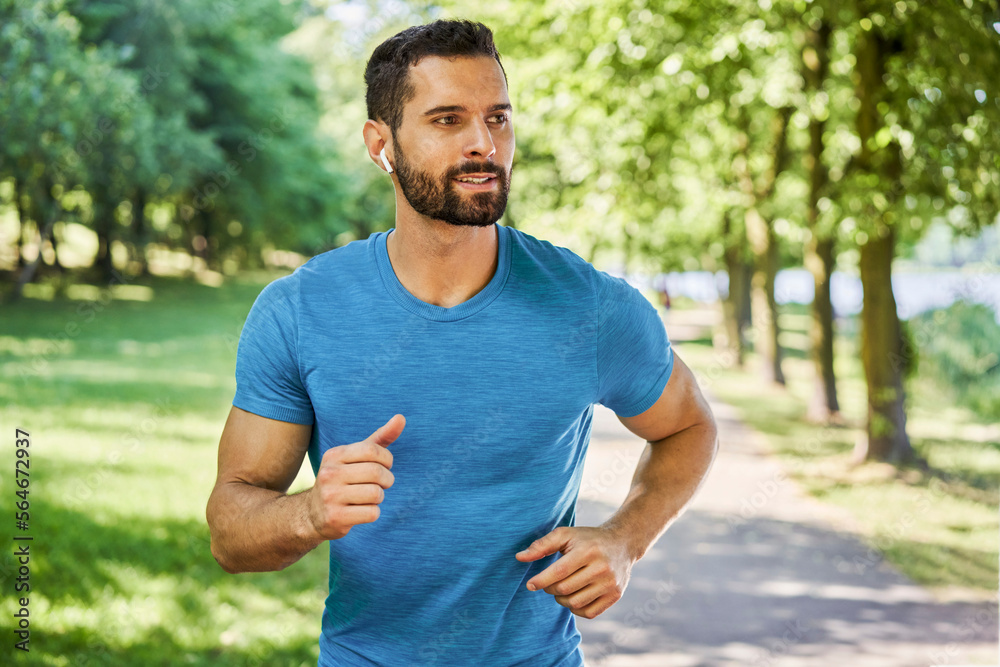 Handsome young man running in park during spring summer Stock Photo ...
