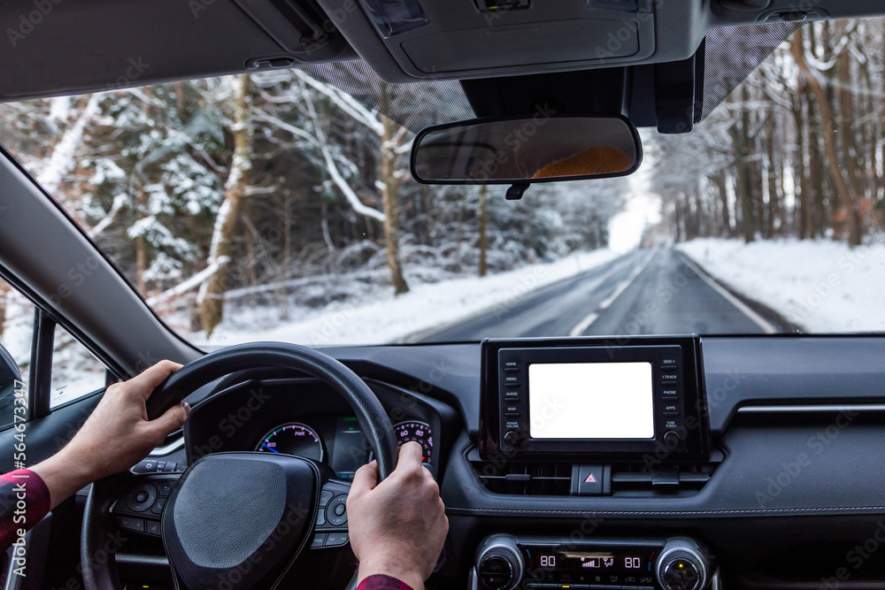 man driving a car on an winter road. back view. Close-up of hands on a ...