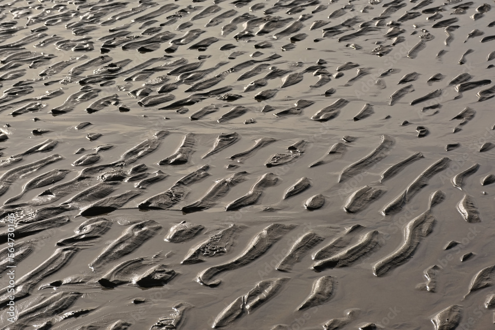 Nature background. rippling patterns in sand with water on the beach ...