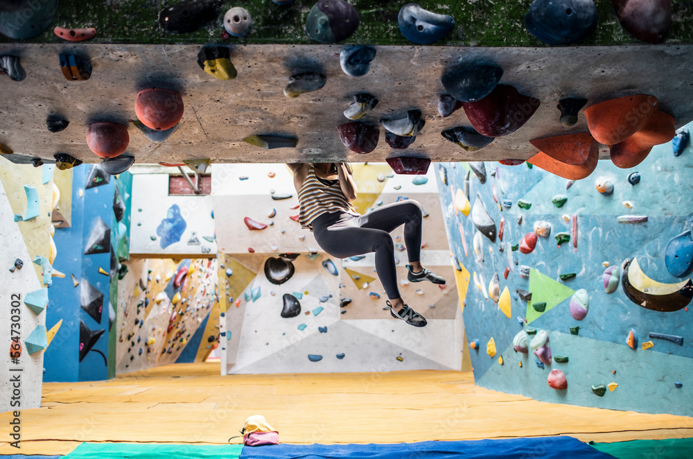 Female rock climber hanging from rock wall Stock Photo | Adobe Stock