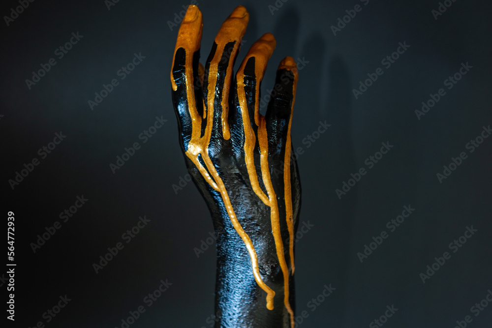 Elegant female hand with black and gold paint on her skin with black ...