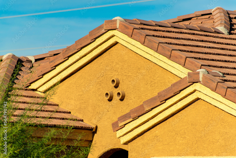 Decorative rooftop facade with adobe style red tiles and double gable ...