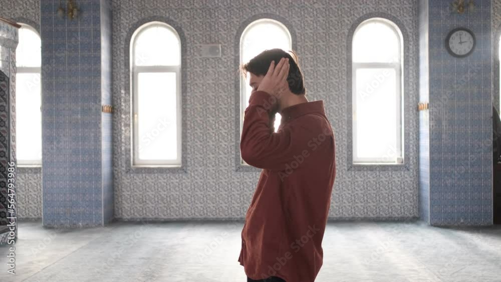 Side view of a bearded Muslim man standing up to pray, the man goes to ...