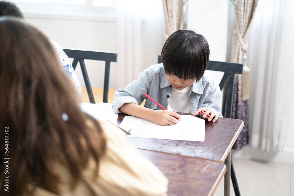 Fotka „Cute primary school students are concentrating and enjoying ...