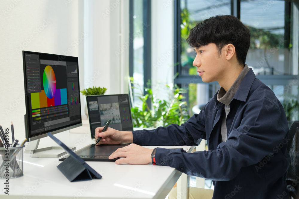 Side view of young creative man using graphic tablet, working with ...