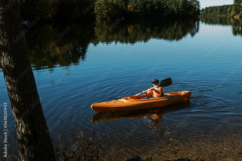 Little boy in a kayak alone and paddling independently on a lake Stock ...