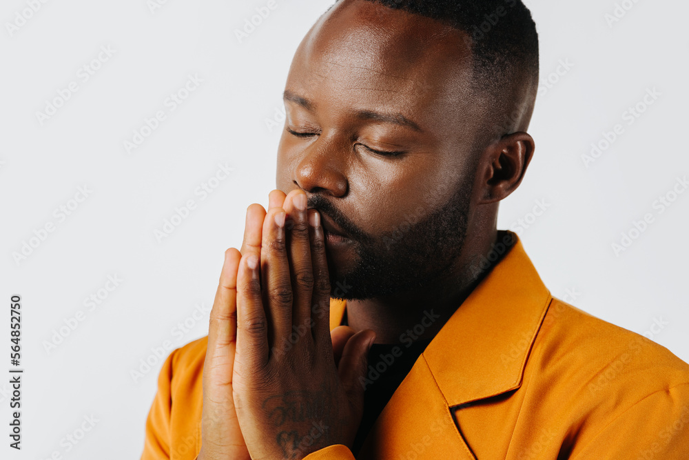Elegant black man with orange suit praying Stock Photo | Adobe Stock