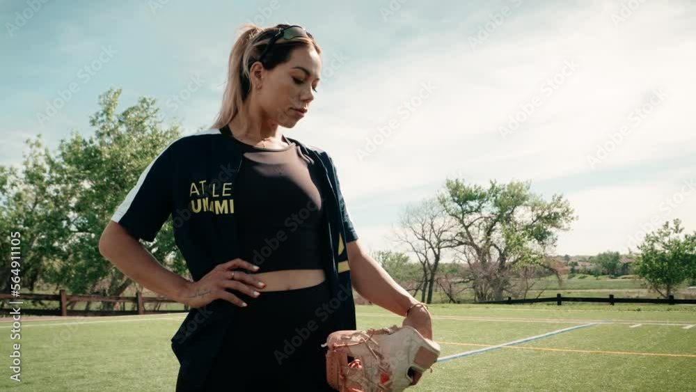 Beautiful female softball athlete strikes a dramatic pose standing ...