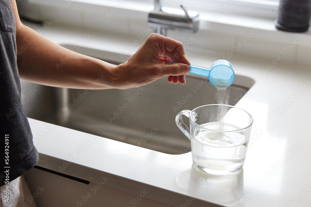 Woman pouring powder supplement in the glass Stock Photo | Adobe Stock