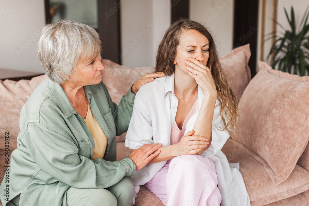 Worried aged mother embracing comforting sad grown up daughter with ...
