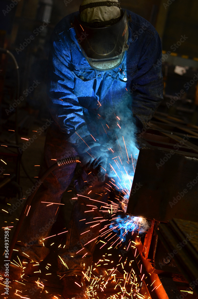 Workers wearing industrial uniforms and Welded Iron Mask at Steel ...