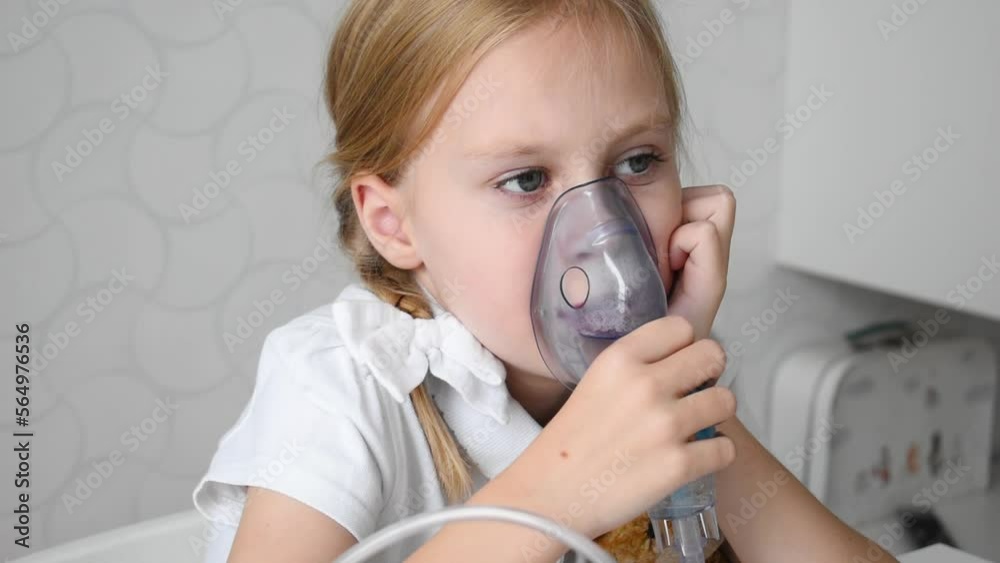 Close-up of a cute little girl makes inhalation with a medical ...