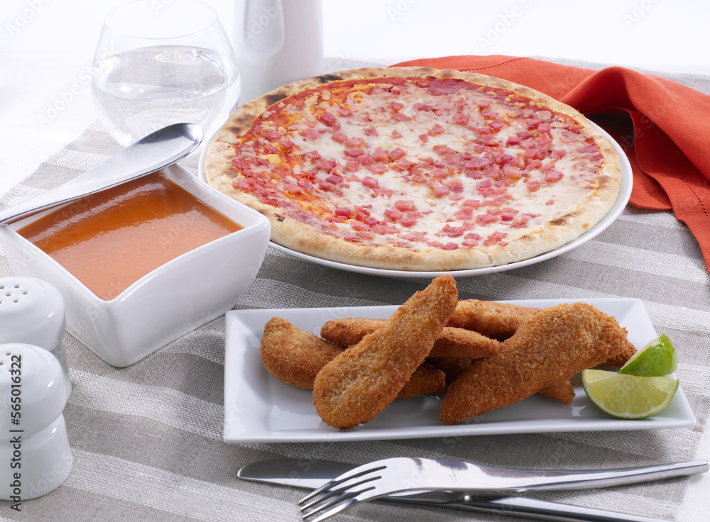 Pechugas de polo empanadas y pizza de jamón y queso. Breaded polo ...