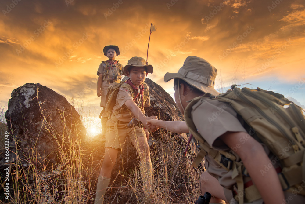 Scouts work as a team. Help each other pull up from the cliff. Stock ...