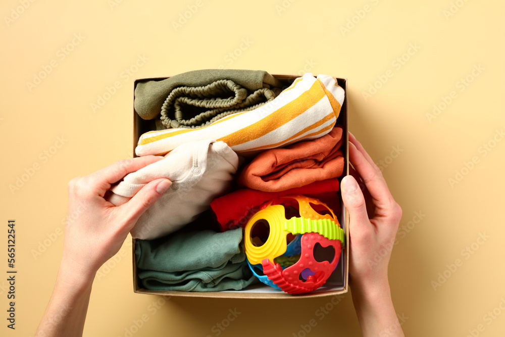 Donation box with kids clothes on a color background. Charity concept ...