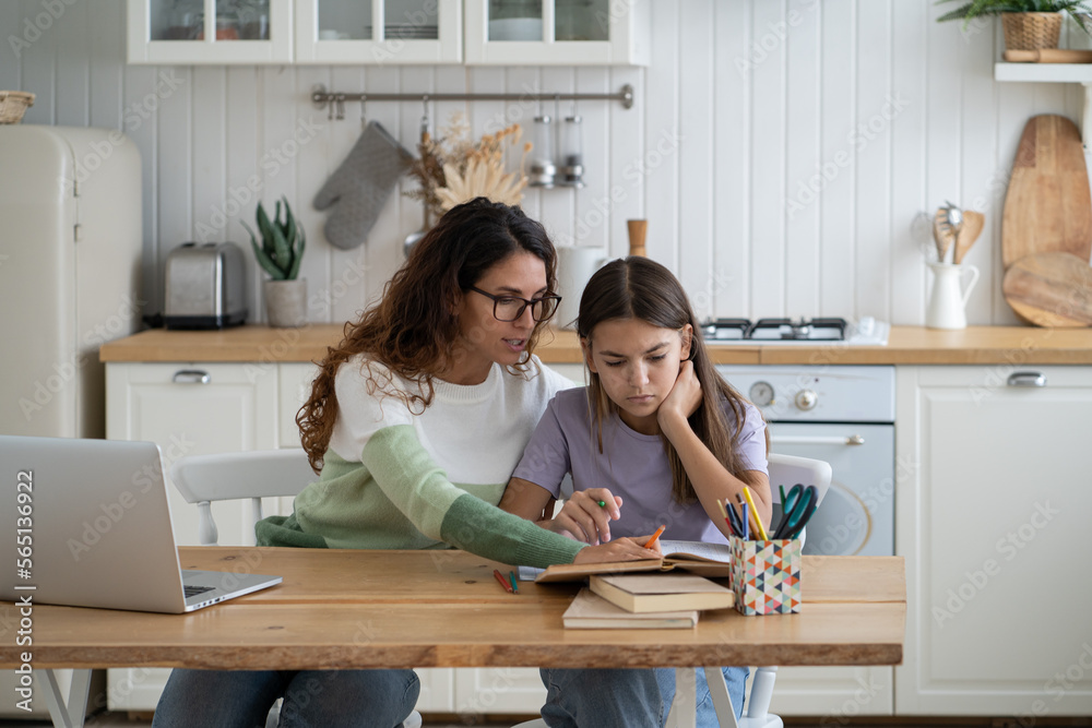 Young mother teaching teen girl daughter at home, mom helping sad ...