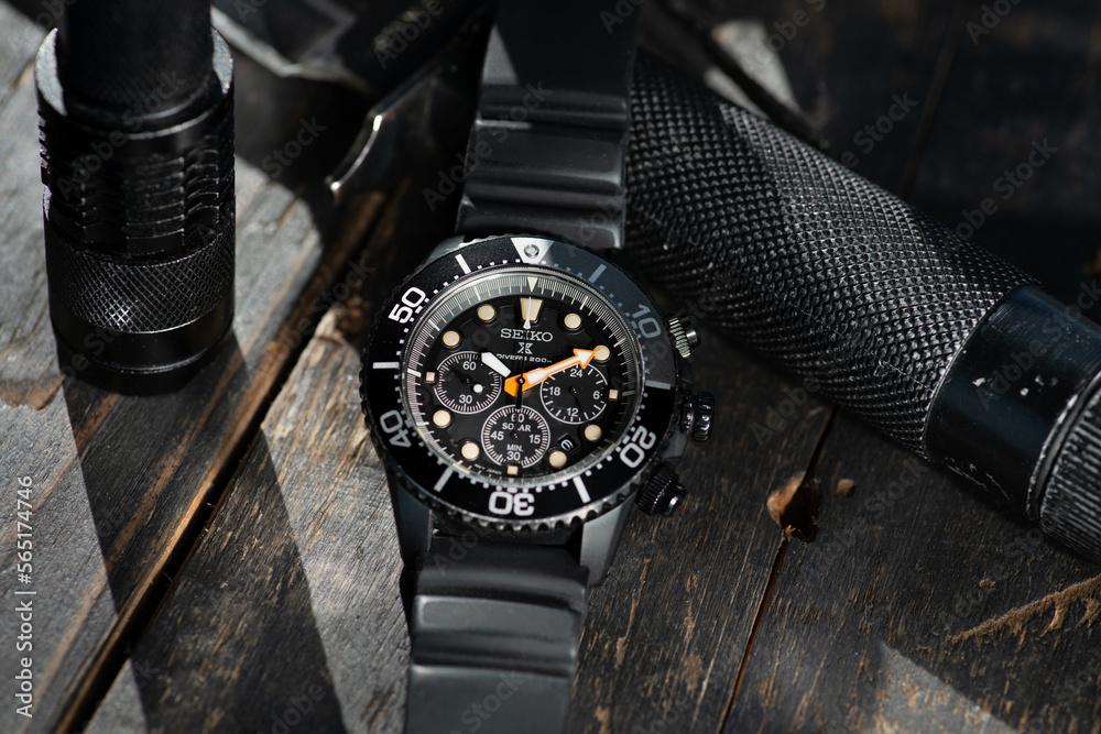 SEIKO Prospex black diver watch and knife on wooden table. Black ...