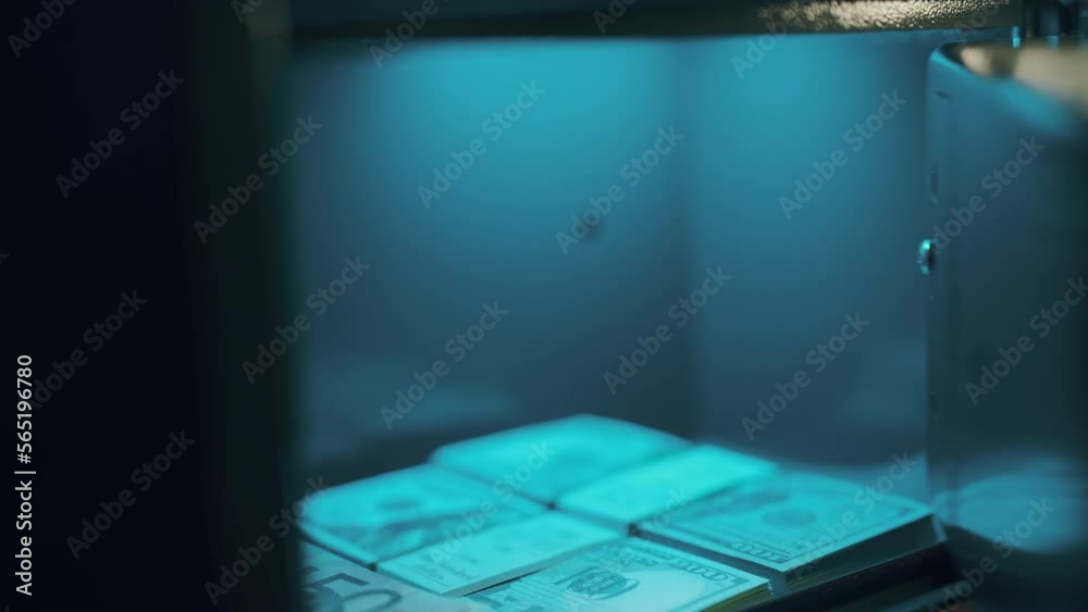 A businessman is dialing secret code and opening safe and putting money ...
