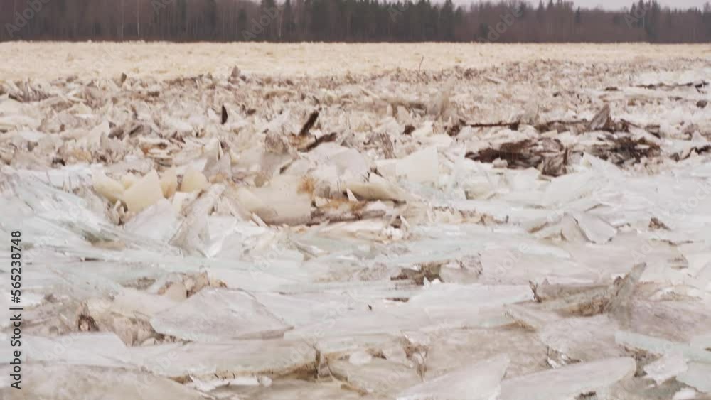 A surging river, swollen with rushing water and massive chunks of ice ...