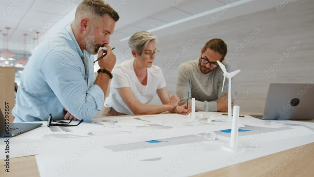 Creative business people working together in an office, designing a ... Creative business people working together in an office, designing a ...