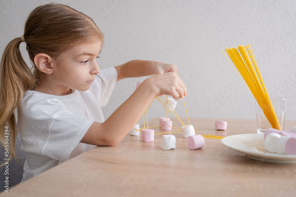 Little girl having fun time learning molecular structure. Concentrated ...