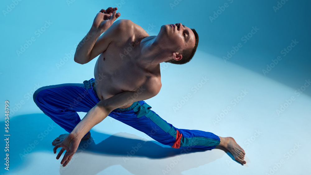 Contemporary dance style. Young shirtless man dancing, performing ...