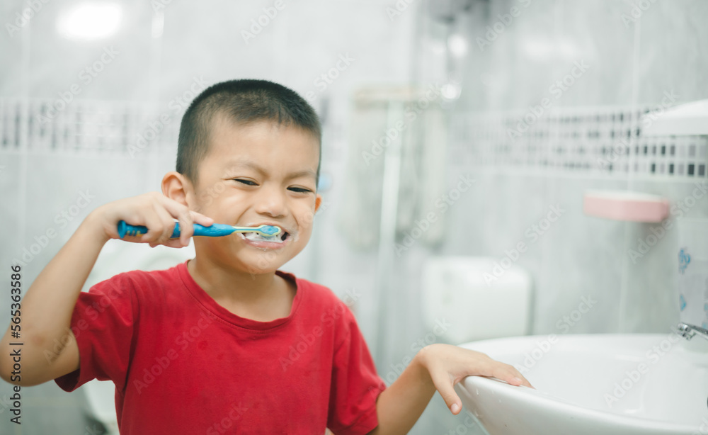Litle boy with Electric toothbrush on bathroom background. Close up ...