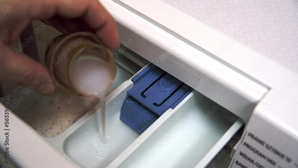 Pouring softener into the container in an automatic washing machine ...