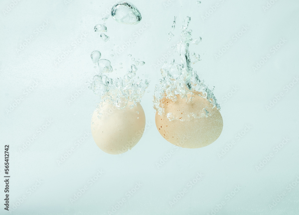 Two eggs fall into transparent water, side view, light background. Eggs in water. Stock Photo ...