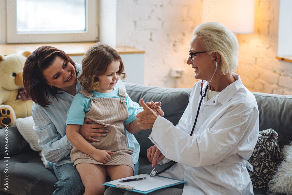 Kind female senior paediatrician doctor visiting his patient at home ...