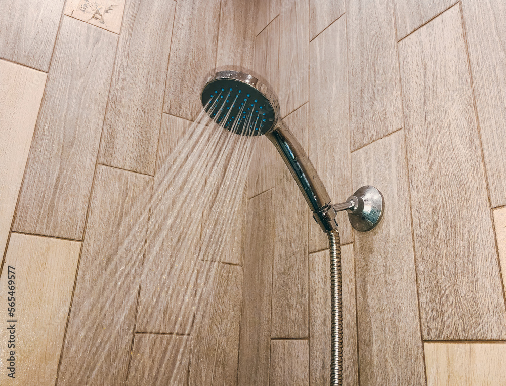 Water flowing from the shower head in the bathroom. Shower head and ...