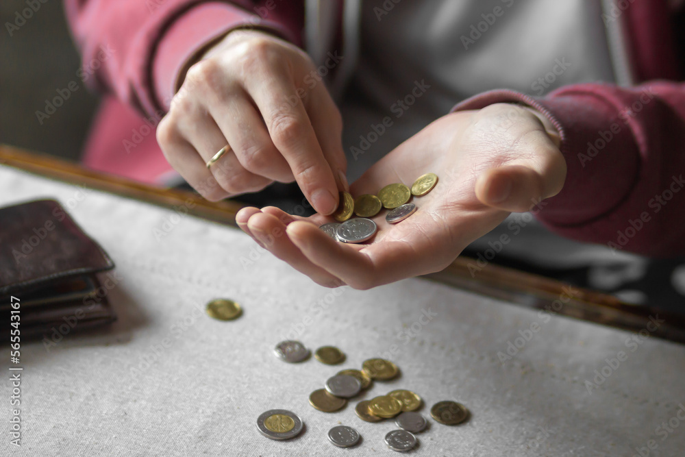 Young man counting coins on table in a period of crisis. Poor man holds ...