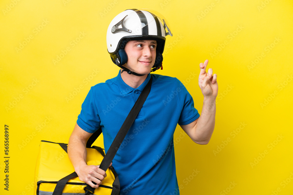 Young Brazilian man with thermal backpack isolated on yellow background ...
