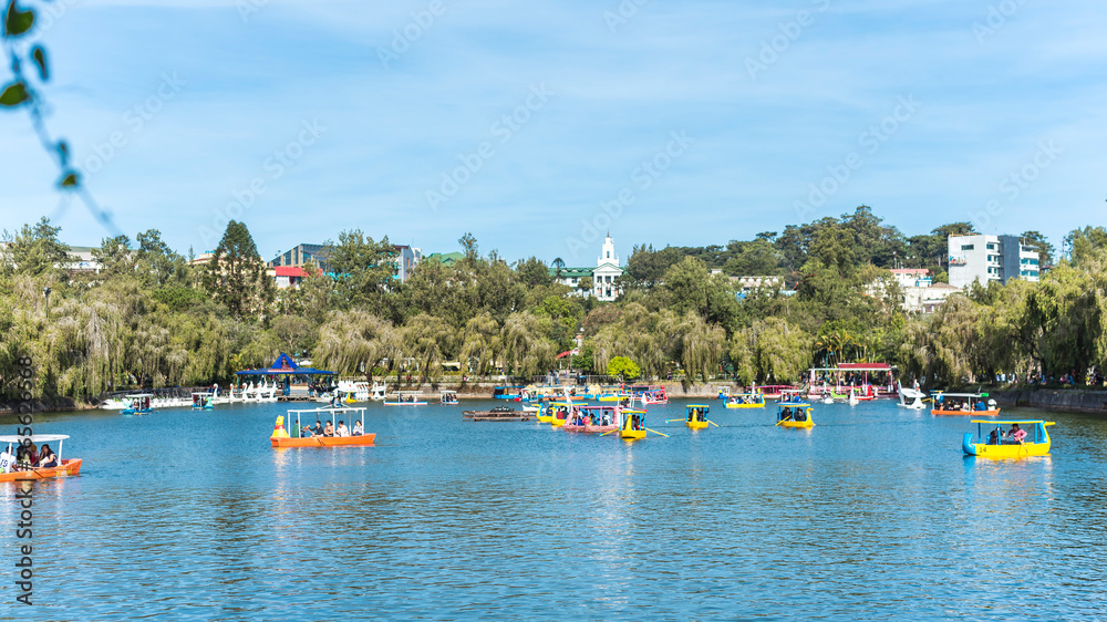 Baguio City, Philippines - Tourist enjoy rowing small boats at a man ...