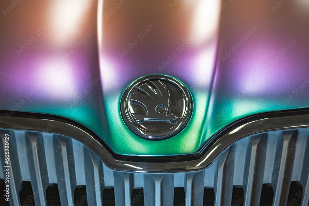 The Skoda nameplate on a chameleon-colored luxury sedan. Skoda badge on ...