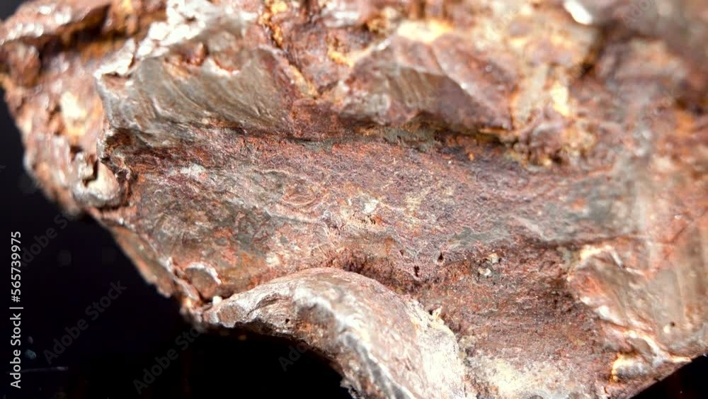 Rotating Of An Iron Meteorite. black background on a mirror base. Close ...