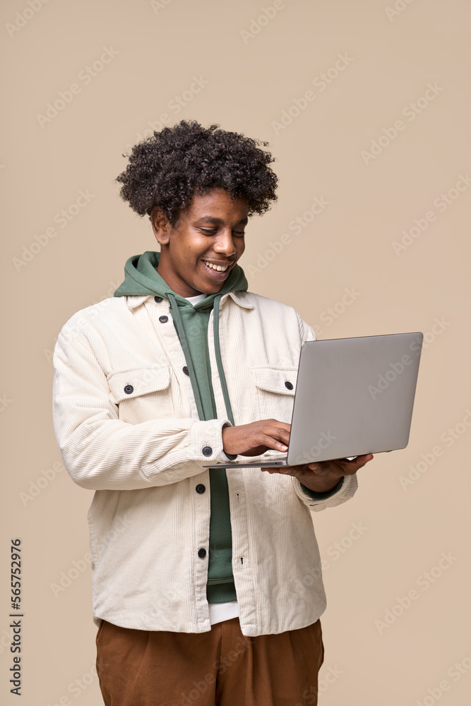 Happy smiling African American teenager student holding laptop using ...