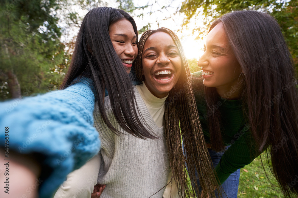 Foto de Portrait of three girls outside having fun taking selfie. An ...