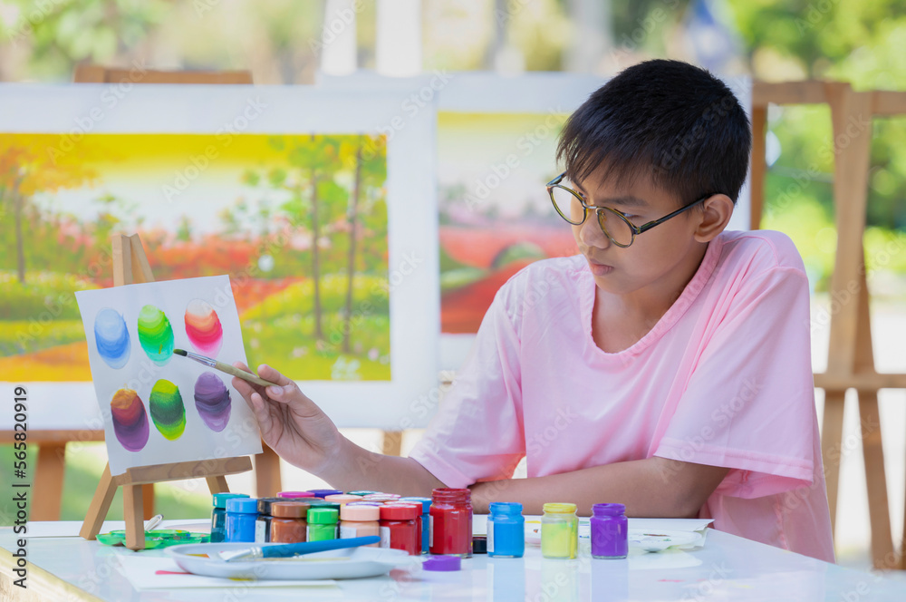 asian teenager boy concentrate in comparing primary colors to practice ...