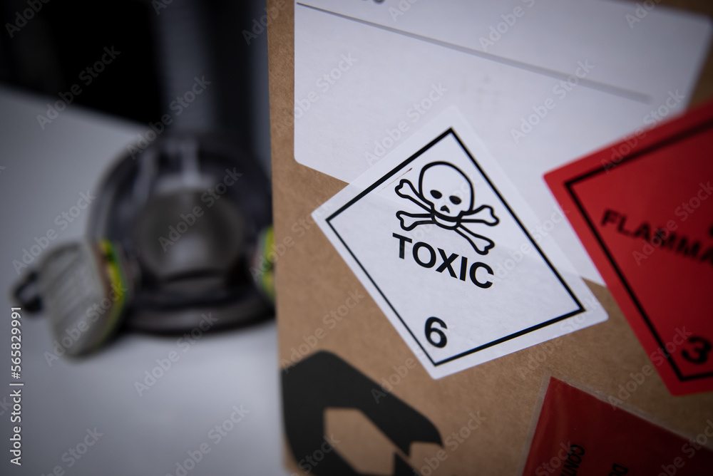 White toxic symbol and red flammable symbol on a box with a mask in the ...