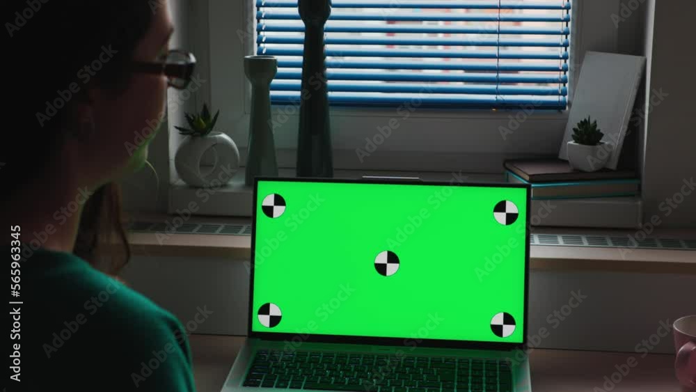 Videocall. Close up of rear view of woman watching at green screen of ...