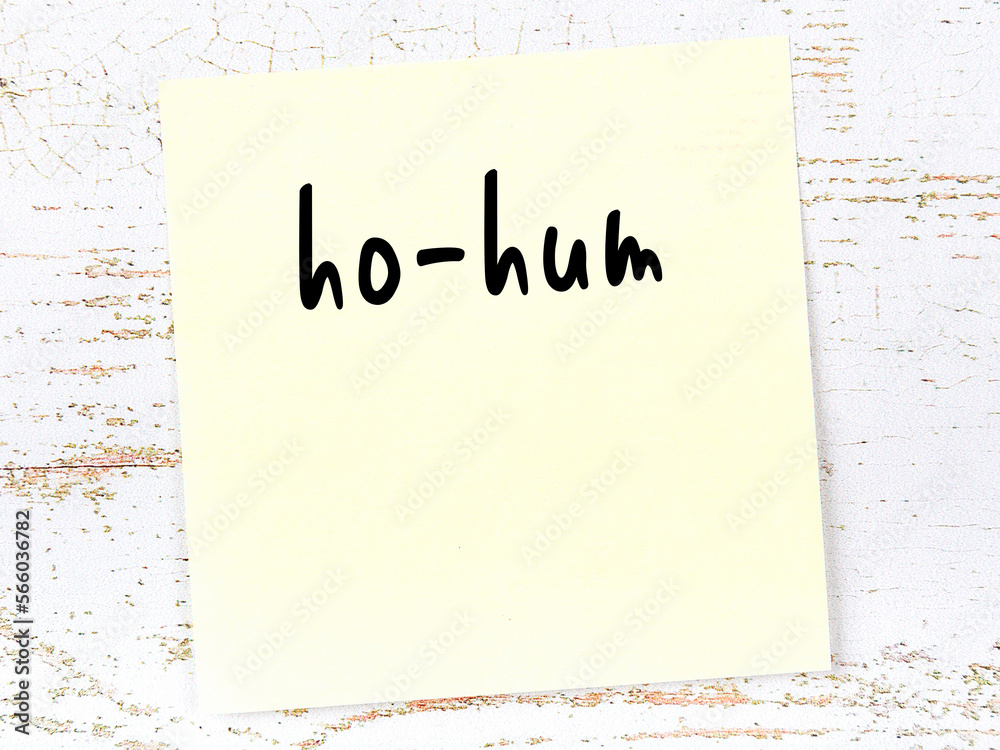 Yellow sticky note on wooden wall with handwritten word ho-hum Stock ...