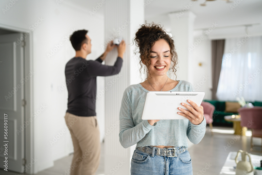 man and woman couple wife husband set up surveillance security camera ...