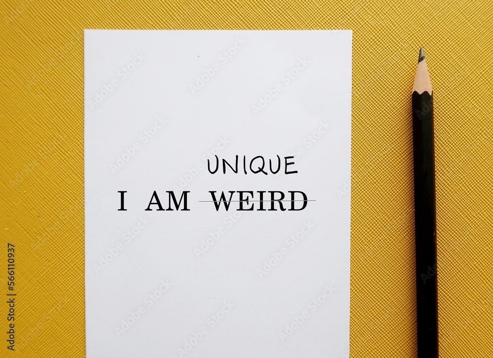 Paper note with handwritten text I AM WEIRD changed to UNIQUE, to ...