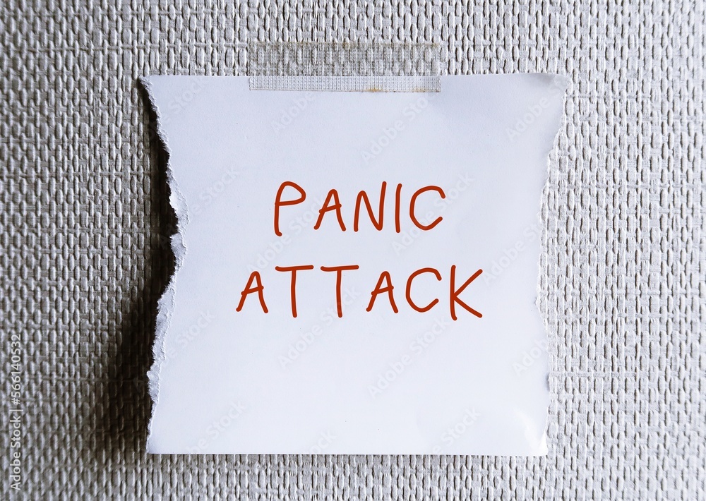 Torn paper note stick on wallpaper with handwritten PANIC ATTACK ...