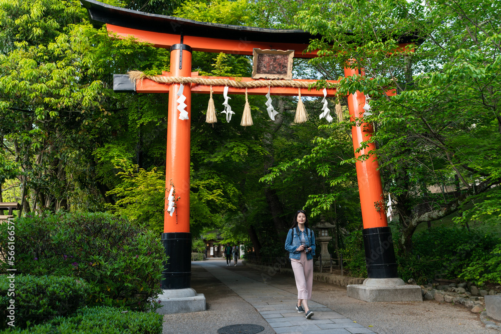 full length of asian Japanese woman visitor walking through a giant red ...